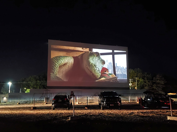 Twilight magic at its finest&mdash;cars gathered under a darkening sky as comedy and tragedy masks illuminate the massive screen at Skyview Drive-In.