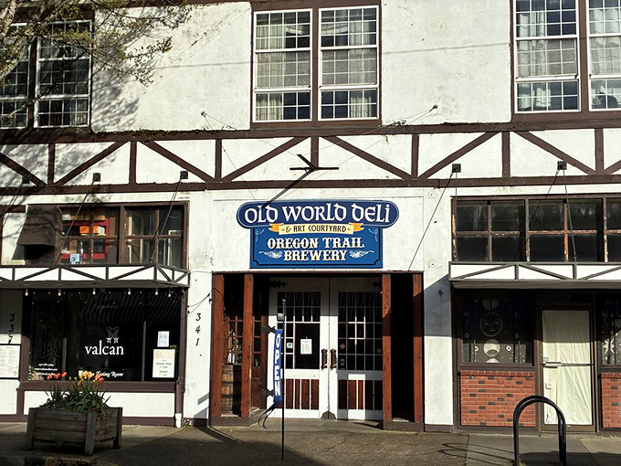 Tudor-style charm meets sandwich paradise at Old World Deli's distinctive exterior. The blue sign promises a delicious adventure waiting just beyond those wooden doors.