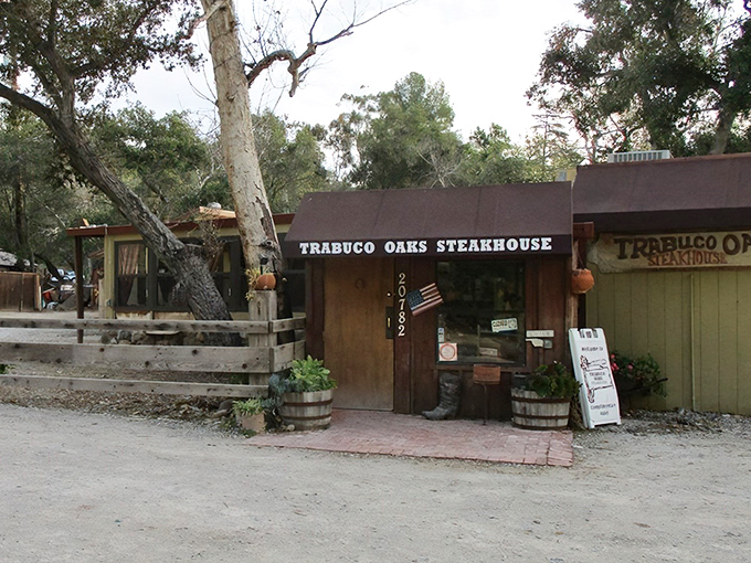 The rustic wooden exterior of Trabuco Oaks Steakhouse beckons like a mirage in the canyon, promising carnivorous delights beneath those towering oak trees.