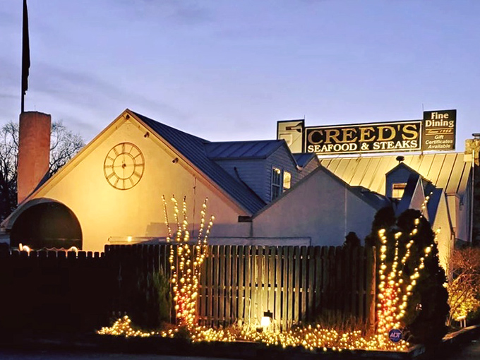 Twilight transforms Creed's into a glowing beacon of culinary promise, its distinctive clock face and twinkling lights beckoning hungry travelers like a gastronomic lighthouse.