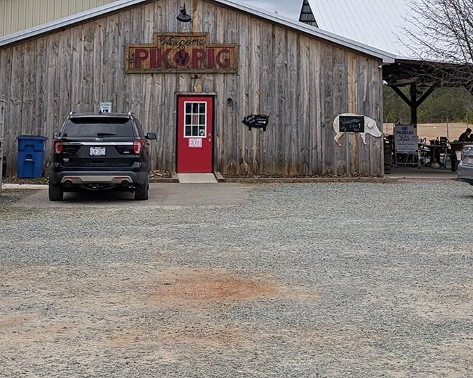 Rustic charm meets serious barbecue at this weathered barn with its distinctive red door. The Pik N Pig sign promises delicious things await inside.