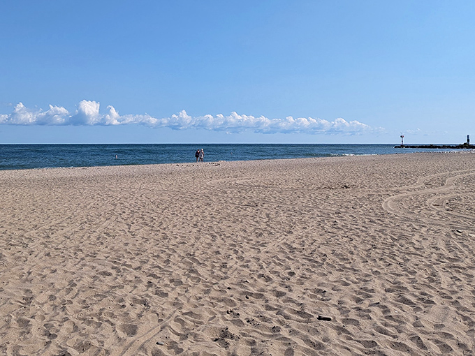 Golden sands stretch toward Lake Erie's horizon, where water meets sky in that perfect vacation tableau you've been searching for all along.