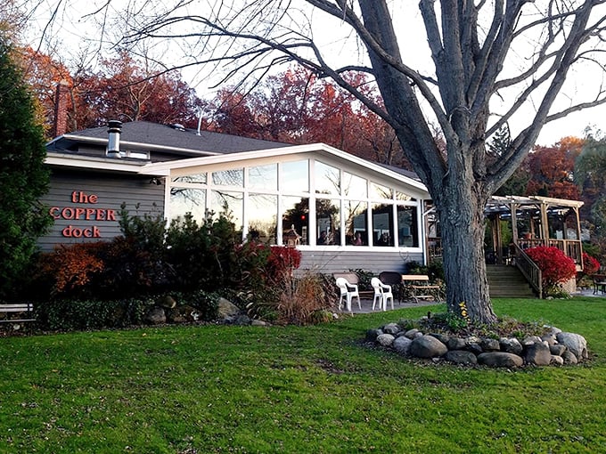 The blue-gray shingled exterior with bright orange signage feels like discovering a secret lakeside hideaway that locals have been keeping to themselves.