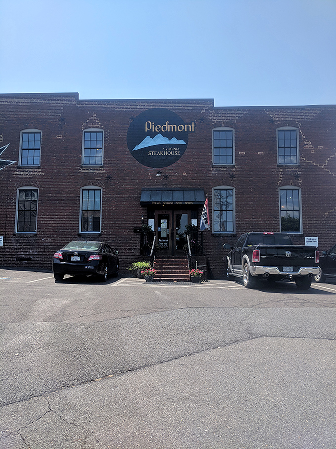 The historic brick exterior of Piedmont Steakhouse stands like a culinary fortress in downtown Culpeper, promising treasures within that the modest fa&ccedil;ade only hints at.