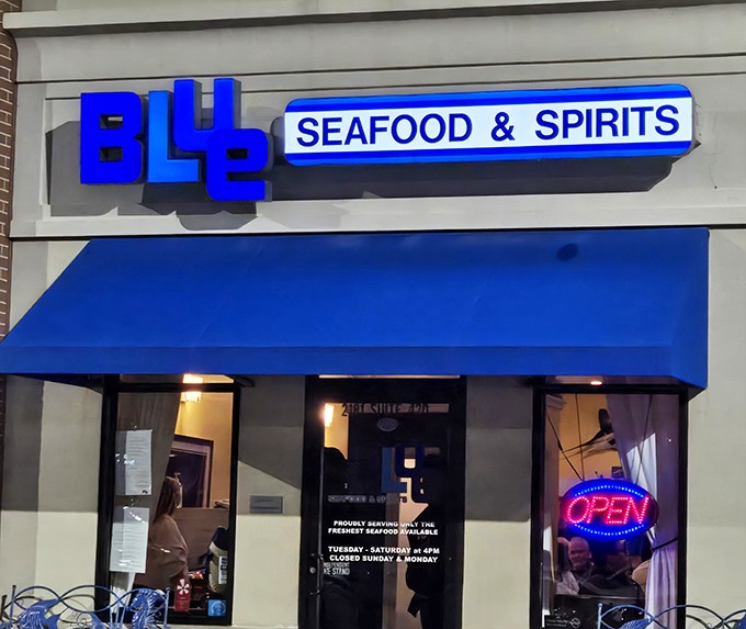 The unassuming blue awning hides culinary treasures within, like Superman disguised as Clark Kent in a strip mall.