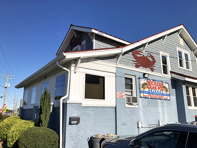 The blue-gray clapboard exterior with its signature red roof stands like a seafood lighthouse, beckoning hungry travelers with promises of crab-filled dreams.