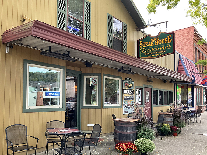 The yellow clapboard exterior of The Steak House in Wellsboro beckons like a beacon of hope for hungry travelers, complete with charming sidewalk seating.