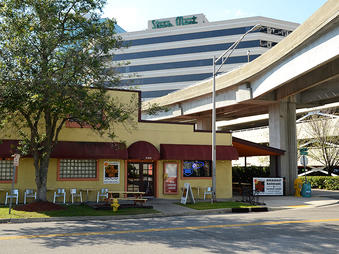 The welcoming exterior of The Southern Grill, with its signature red awning and outdoor seating, promises comfort food treasures within. Open seven days a week for your barbecue emergencies.