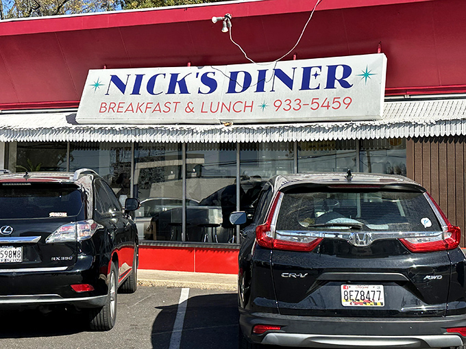 The classic red awning and bold blue lettering of Nick's Diner isn't just signage&mdash;it's a promise of unpretentious breakfast perfection waiting just beyond those newspaper boxes.