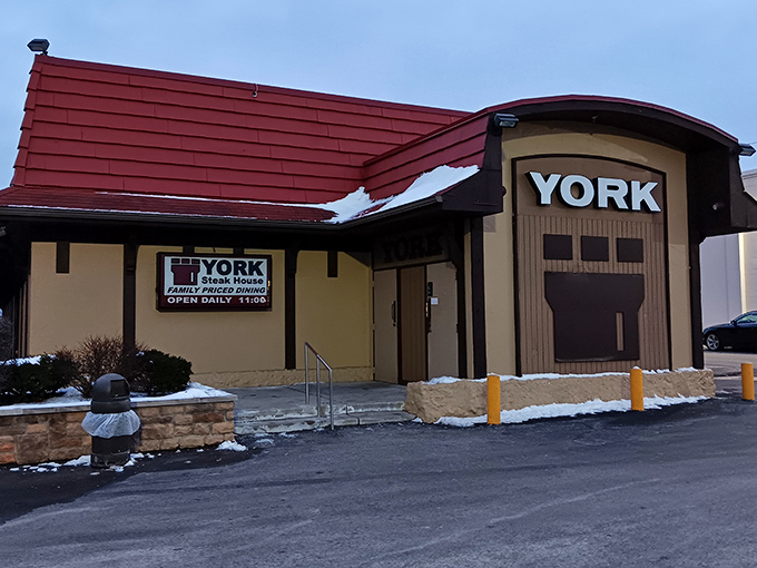 The red-roofed Tudor exterior stands like a culinary time capsule on West Broad Street, promising carnivorous delights that have satisfied Columbus diners for decades.