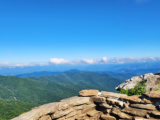 Layer upon layer of blue-tinged mountains stretch to the horizon, with nature's own stone wall providing the perfect foreground for your "I'm on top of the world" moment.
