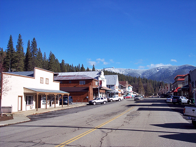 Main Street charm meets mountain majesty in Greenfield, where storefronts stand like sentinels against a backdrop of snow-dusted peaks.