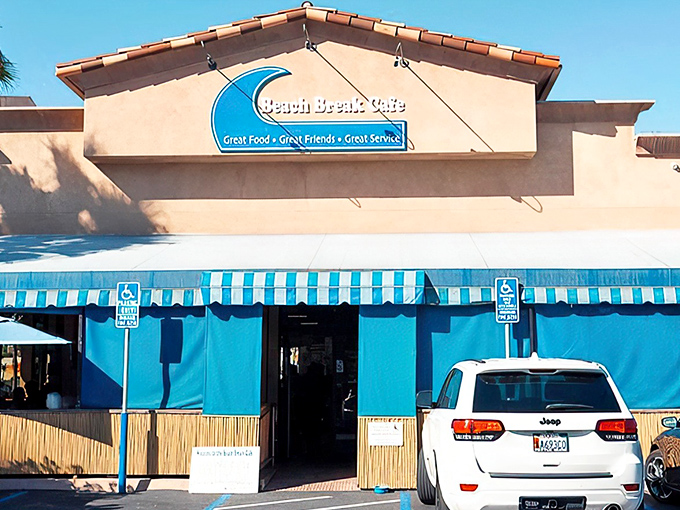 The blue-awninged beacon of breakfast bliss beckons hungry beachgoers with its promise of coastal comfort food and surfside charm.