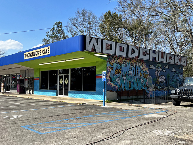 The vibrant blue exterior and eye-catching mural of Woodchuck's Cafe stands out like a beacon of breakfast hope in Tallahassee's morning landscape.