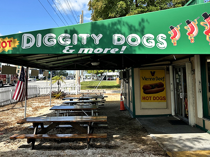 The emerald green awning of Hot Diggity Dogs beckons like a culinary lighthouse, promising simple pleasures and picnic table perfection.