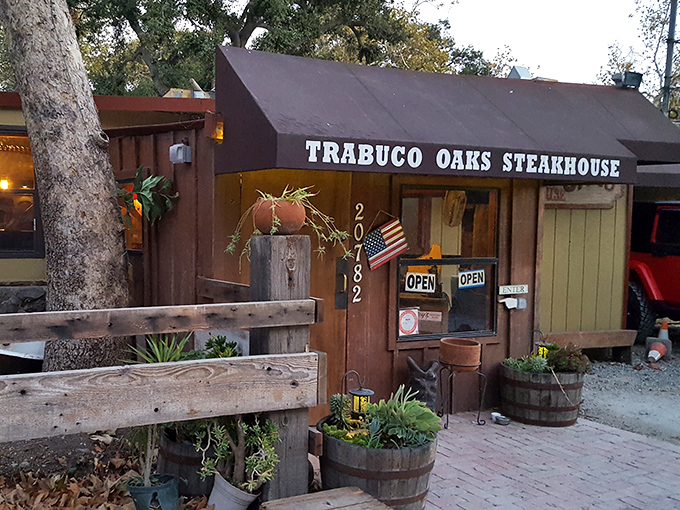 The rustic wooden exterior of Trabuco Oaks Steakhouse beckons like a mirage in the canyon, promising carnivorous delights beneath those towering oak trees.