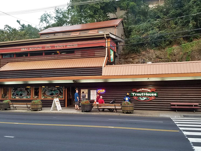The rustic wooden exterior of Smoky Mountain Trout House stands like a culinary time capsule amid Gatlinburg's tourist attractions, promising authentic mountain flavors inside.