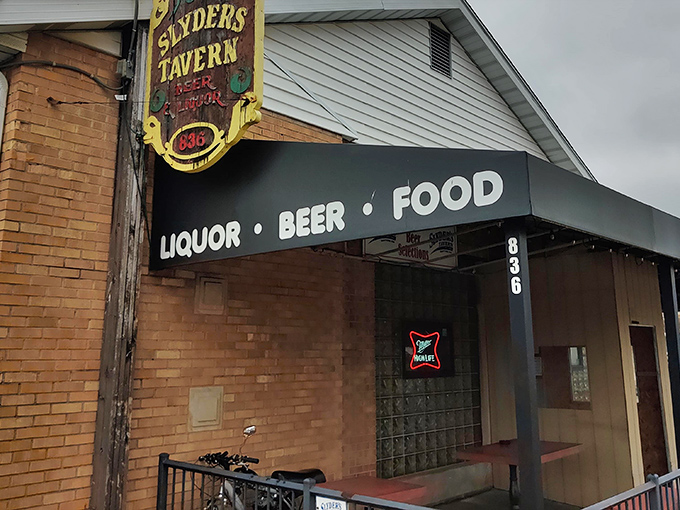 The unassuming exterior of Slyder's Tavern stands like a culinary speakeasy, its modest white siding and vintage sign promising delicious secrets within.