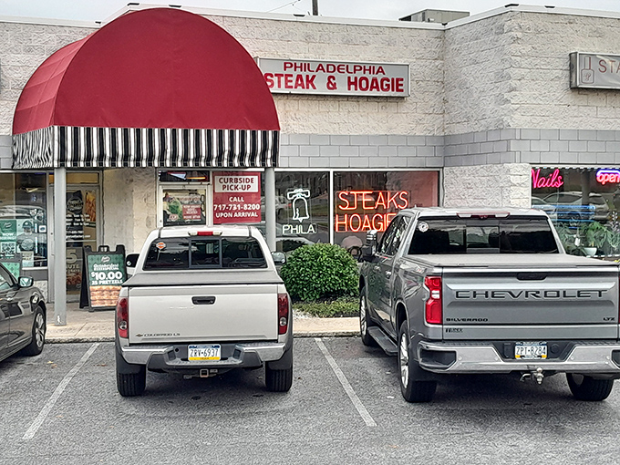 The iconic red awning beckons like a culinary lighthouse, promising authentic Philadelphia flavors in the heart of Camp Hill.