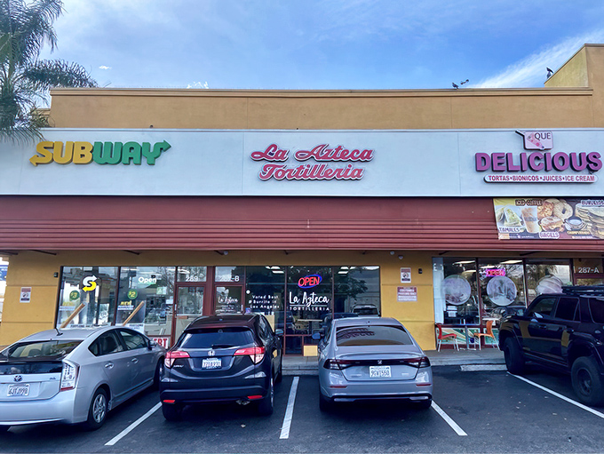 The vibrant red and yellow fa&ccedil;ade of La Azteca Tortilleria stands like a beacon of culinary promise on Cesar Chavez Avenue.