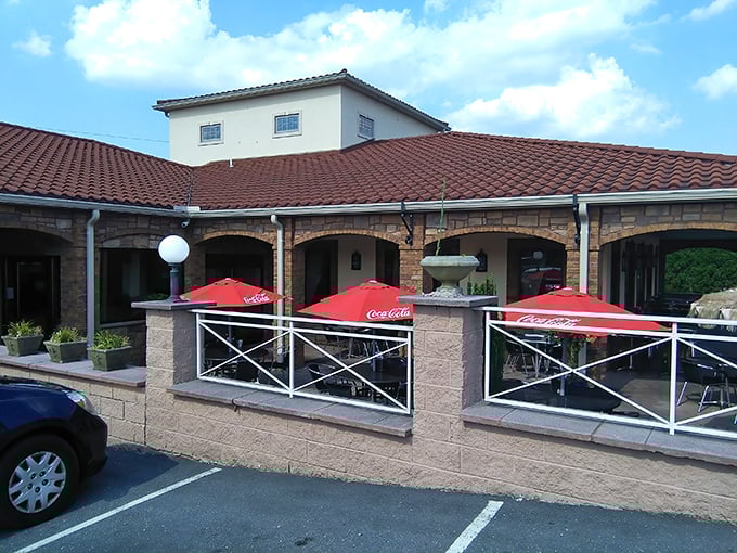 Mediterranean charm meets Pennsylvania practicality at JoJo's exterior, where those red umbrellas beckon like old friends promising good times and better pizza.