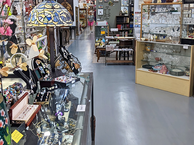 Wide, polished aisles stretch into infinity, each turn promising new discoveries. The Tiffany-style lamp beckons like a lighthouse for vintage souls.