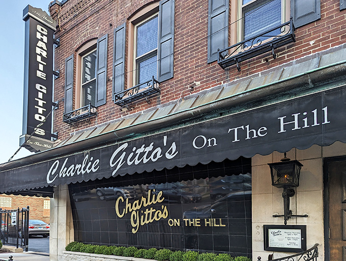 The classic brick exterior of Charlie Gitto's, with its vintage Michelob sign, stands as a beacon of Italian culinary tradition in St. Louis' historic Hill neighborhood.