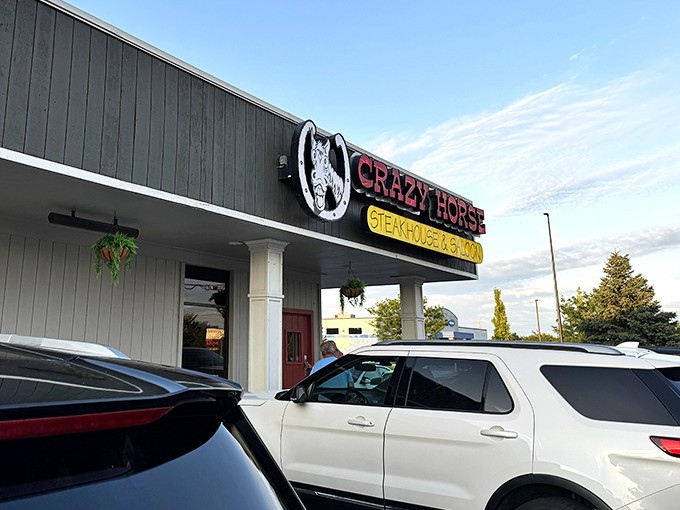 The unassuming exterior of Crazy Horse Steak House hides a carnivore's paradise within. Like finding a treasure map in your attic, this sign points to delicious adventures.