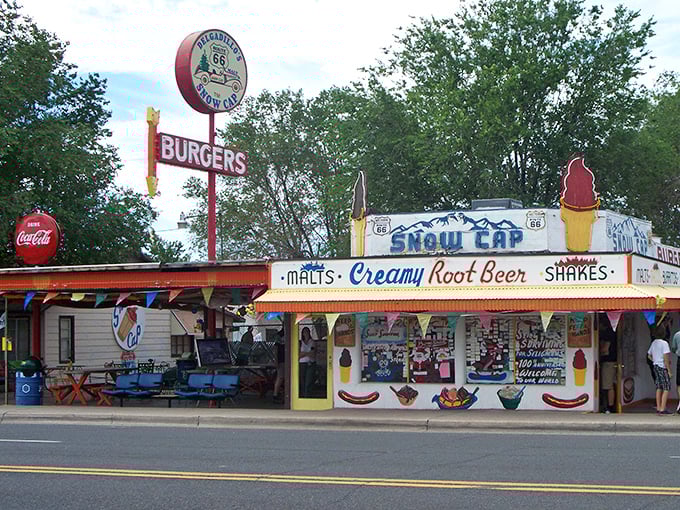 The Snow Cap's vibrant exterior is like a neon-lit time machine to the 1950s, complete with that iconic ice cream cone beckoning hungry travelers.