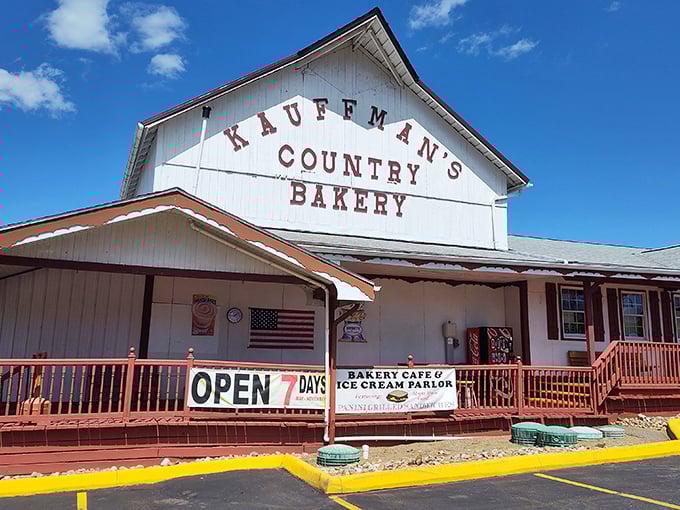 The iconic white barn facade of Kauffman's Country Bakery stands proudly against Ohio's blue sky, promising carb-laden treasures within.