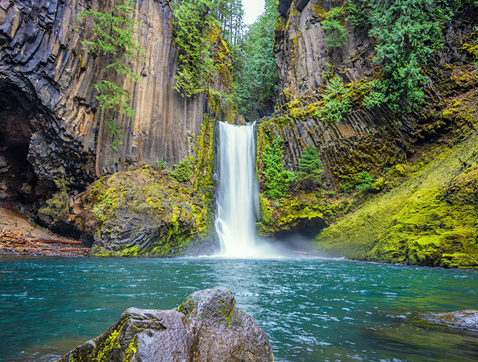 Nature's perfect frame: columnar basalt walls cradle the two-tiered Toketee Falls as it plunges into a pool so blue it looks Photoshopped. Oregon magic at its finest.