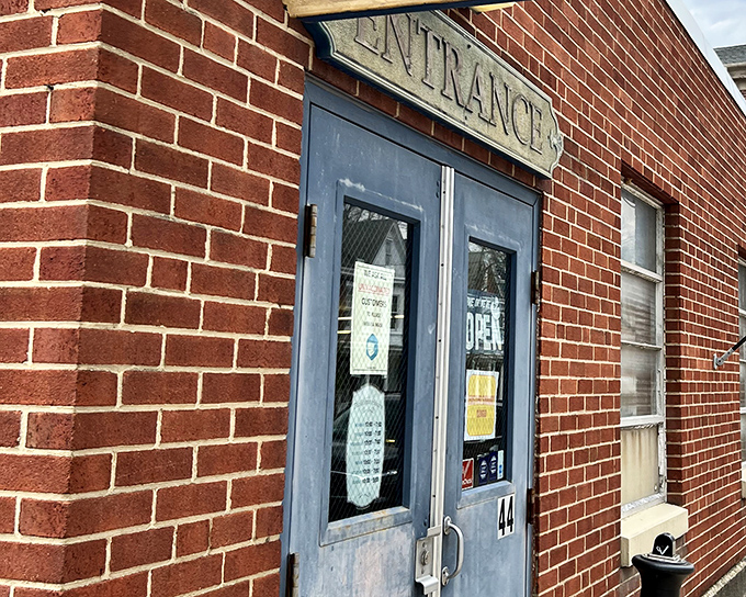 The unassuming brick exterior of Bedford Street Antiques betrays nothing of the wonderland within. That "ANTIQUES" flag is the understated invitation to a time-traveling adventure.