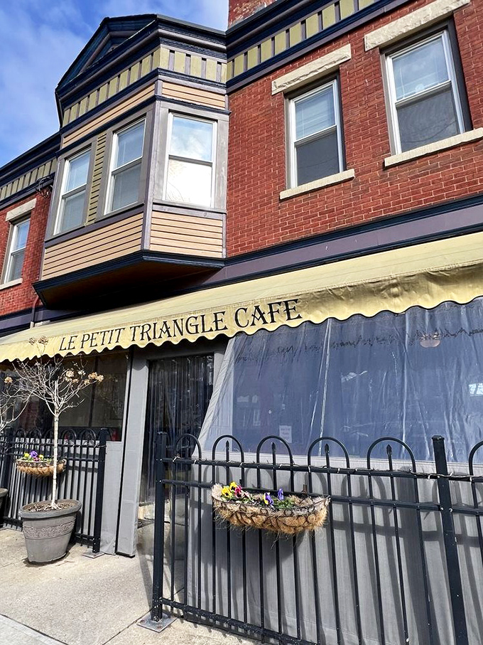 The charming brick facade of Le Petit Triangle Cafe beckons with its distinctive yellow awning and wrought-iron fence&mdash;a little slice of Paris on a Cleveland corner.