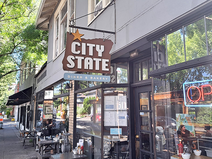 The iconic Oregon-shaped sign welcomes hungry patrons to City State Diner & Bakery, where Portland's breakfast dreams come true under leafy neighborhood trees.