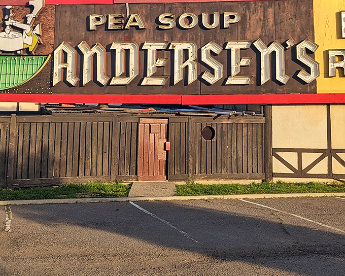 The iconic Tudor-style exterior of Pea Soup Andersen's welcomes road-weary travelers with its charming "Velkommen" sign and those famous cartoon pea-splitting mascots.