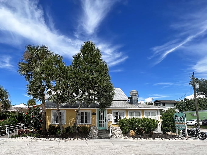 The cheerful yellow cottage with its mint-green door stands like a tropical beacon under Florida's impossibly blue sky.