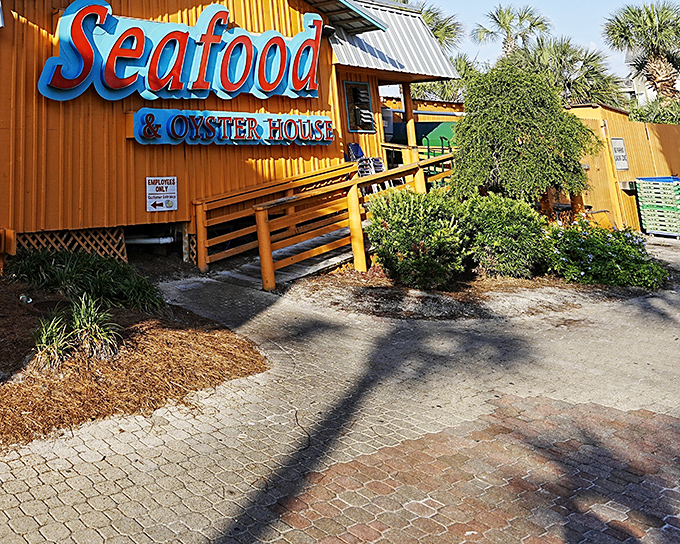 The Back Porch's rustic wooden exterior and bright red "Seafood" sign stand as a beacon for hungry beachgoers seeking Gulf treasures.