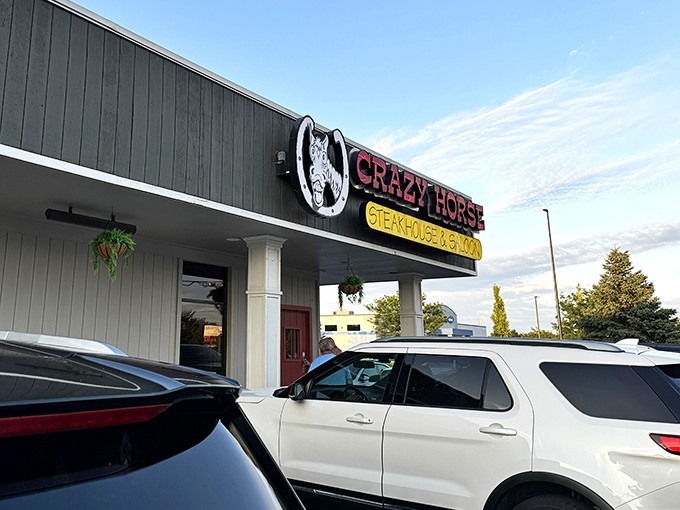 The unassuming exterior of Crazy Horse Steak House hides a carnivore's paradise within. Like finding a treasure map in your attic, this sign points to delicious adventures.