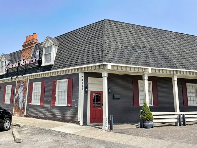 The colonial-style exterior of Redcoat Tavern stands proudly on Woodward Avenue, its red shutters and iconic sign promising comfort food magic within.