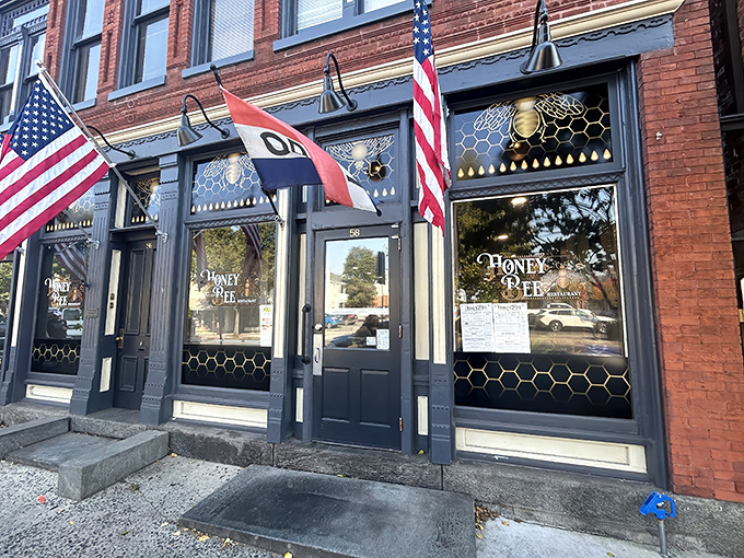The historic brick fa&ccedil;ade of Honey Bee Restaurant stands proudly in Gettysburg, its honeycomb-patterned windows and American flags promising both comfort and patriotism inside.