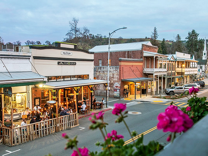 Main Street stretches before you like a living postcard, where historic buildings stand proudly against the backdrop of autumn-kissed foothills.