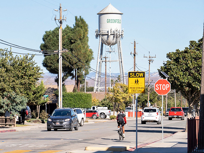 Main Street charm meets mountain majesty in Greenfield, where storefronts stand like sentinels against a backdrop of snow-dusted peaks.