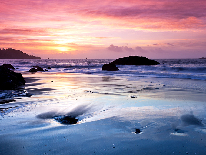Nature's perfect sunset canvas unfolds at Marshall's Beach, where golden hour transforms ordinary sand and rocks into a masterpiece worthy of the Louvre.