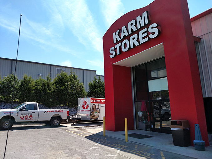 The iconic red entrance of KARM Stores stands like a beacon for treasure hunters, promising adventures in secondhand paradise under Tennessee's blue skies.