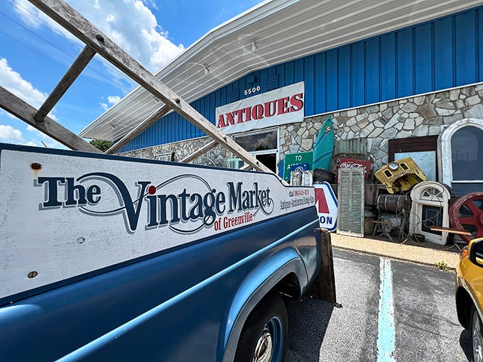 The blue-fronted time machine beckons with its "ANTIQUES" sign, while vintage treasures spill onto the sidewalk like impatient children.
