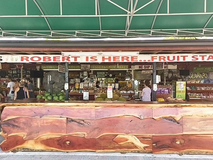 The wooden counter stretches like a rustic welcome mat, with "ROBERT IS HERE" proudly announcing itself to fruit pilgrims seeking tropical treasures.