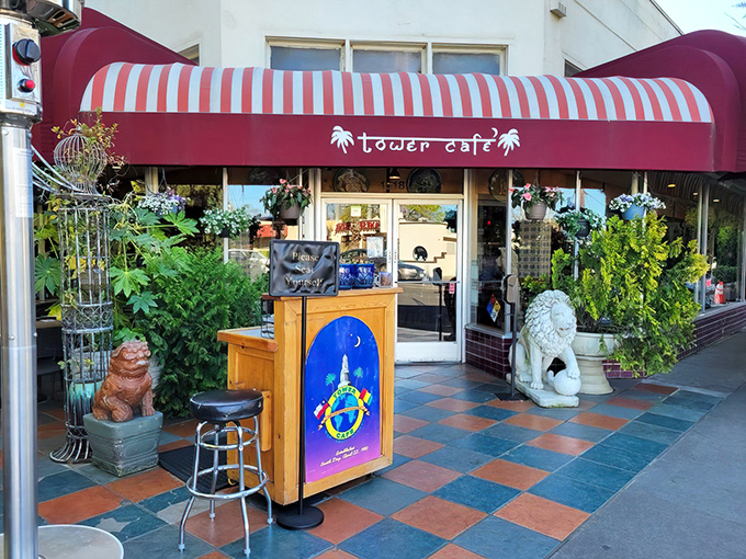 The entrance to Tower Caf&eacute; feels like stumbling upon a secret garden oasis, complete with guardian statues and a red awning that practically winks at you.
