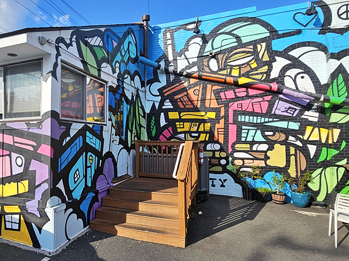 Street art meets comfort food at Cowboy Cafe's vibrant exterior. The colorful mural and wooden steps invite you into Arlington's hidden gem.