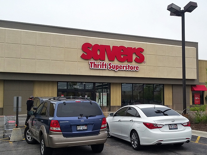 The bold red Savers sign beckons like a lighthouse for bargain hunters navigating the sea of retail sameness.