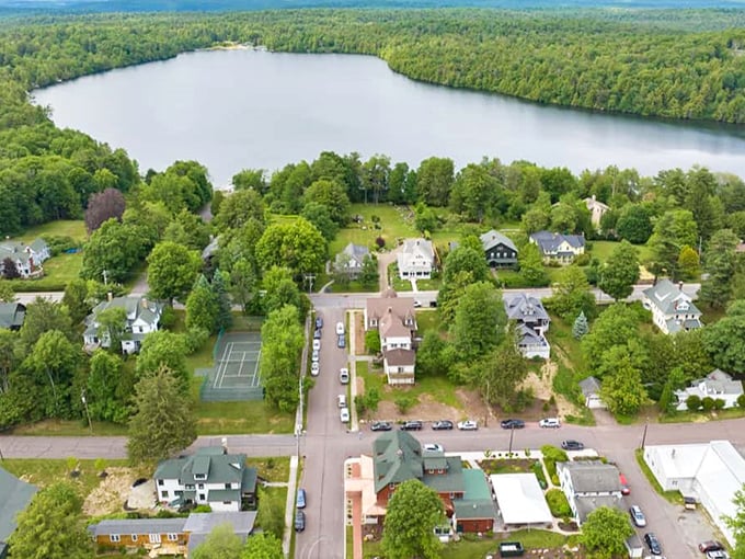Downtown Eagles Mere showcases its timeless charm with a vintage clock standing sentinel among blooming rhododendrons &ndash; small-town Americana at its picture-perfect best.